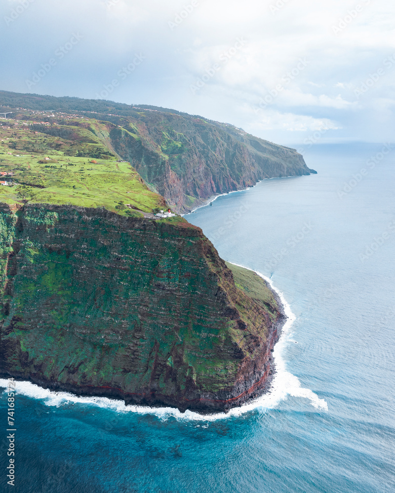 Aerial drone view of Madeira coastline, lighthouse and cliffs from ...
