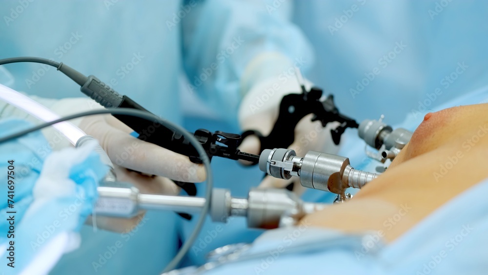Hands of surgeons with the help of endoscopic equipment and instruments ...