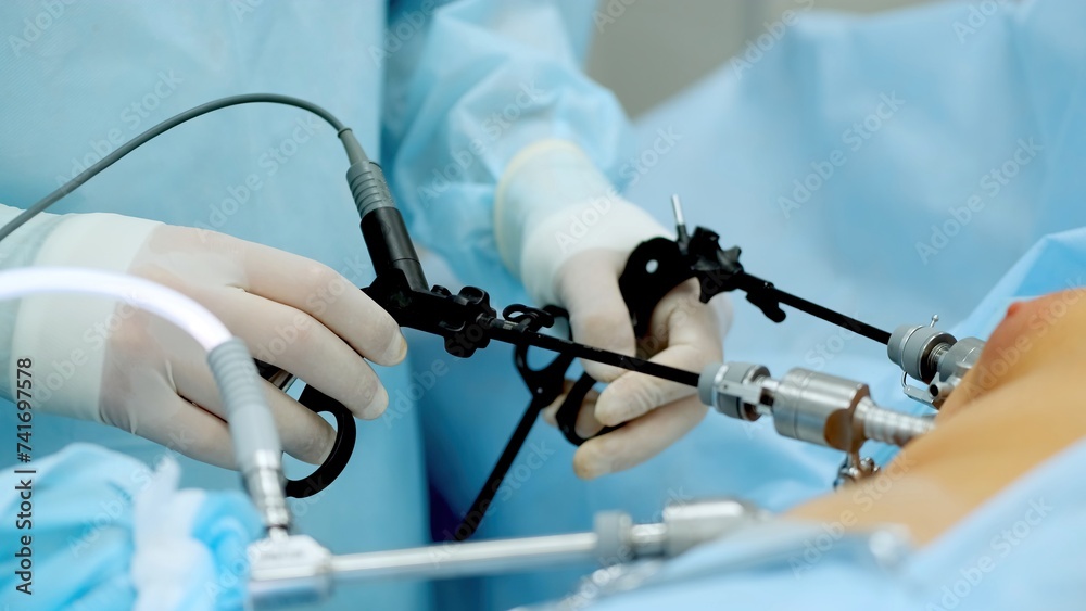 Hands of surgeons with the help of endoscopic equipment and instruments ...
