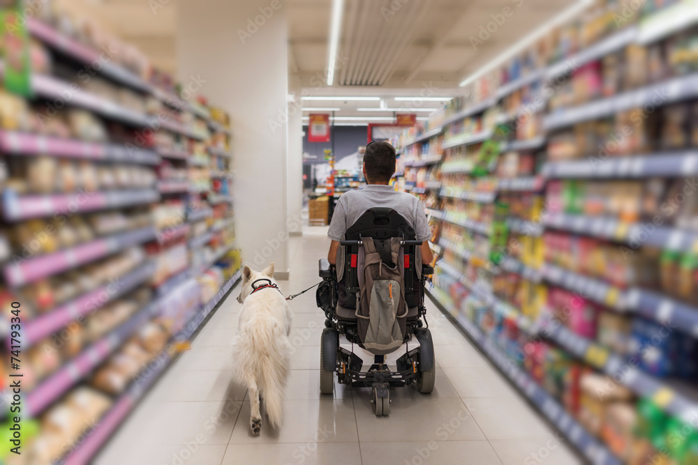 Man with disability and his service dog shopping in market store using ...