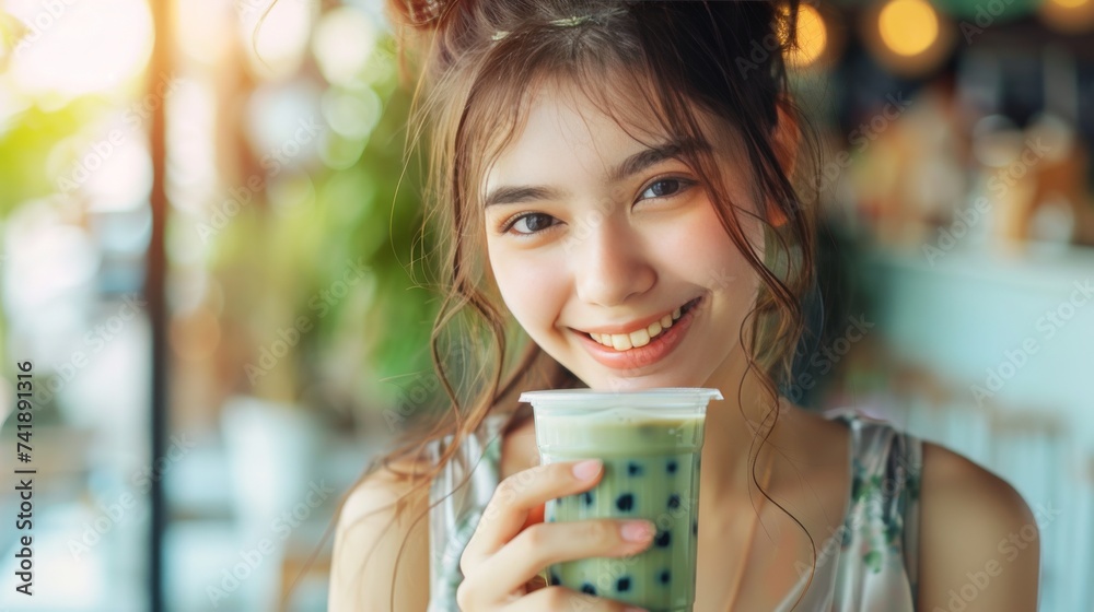 Smiling teenage girl drinking and enjoying Matcha Bubble boba milk tea ...