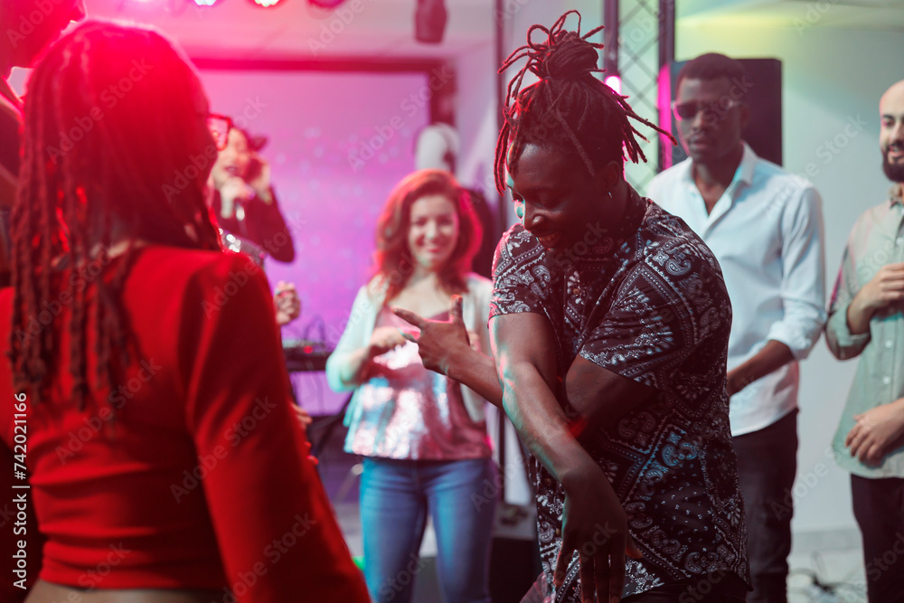 African american couple showing moves on crowded dancefloor in ...