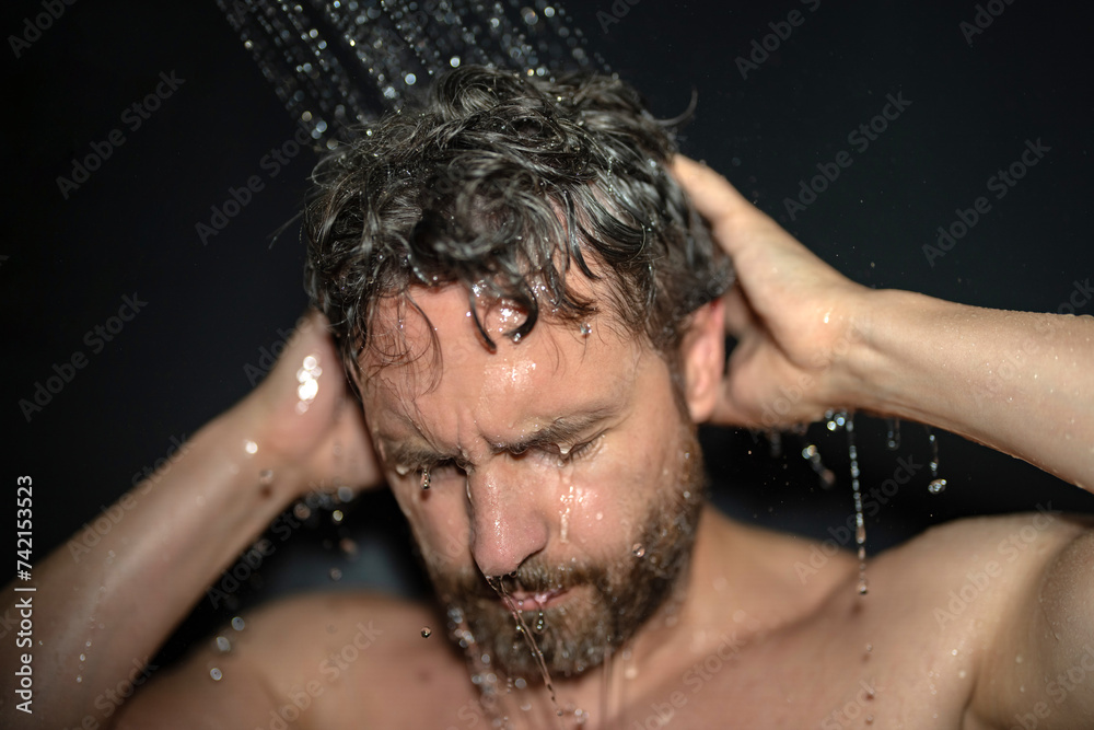 Millennial man washing hair in bath. Guy bathing shower head in bathtub ...