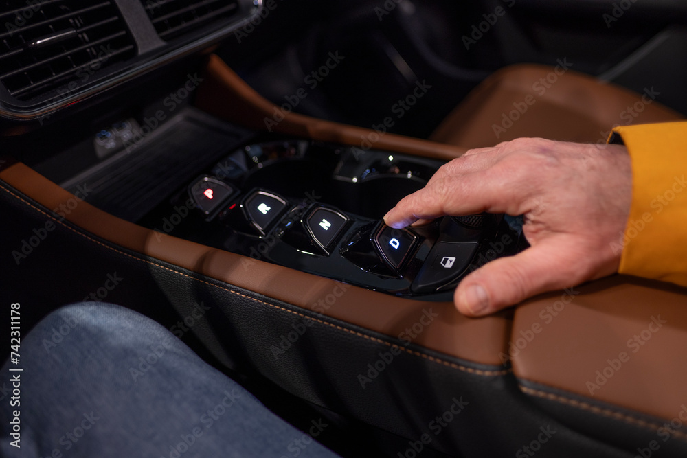 male hand uses ergonomic center console, button switches Vinfast vf 8 ...