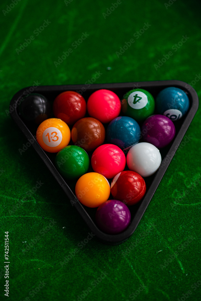 Overhead view of snooker balls in a triangle snooker frame on a green ...