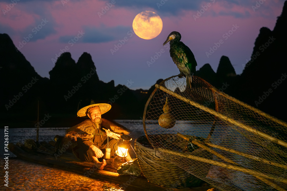 Traditional Chinese Fisherman taking a break on bamboo raft with two ...