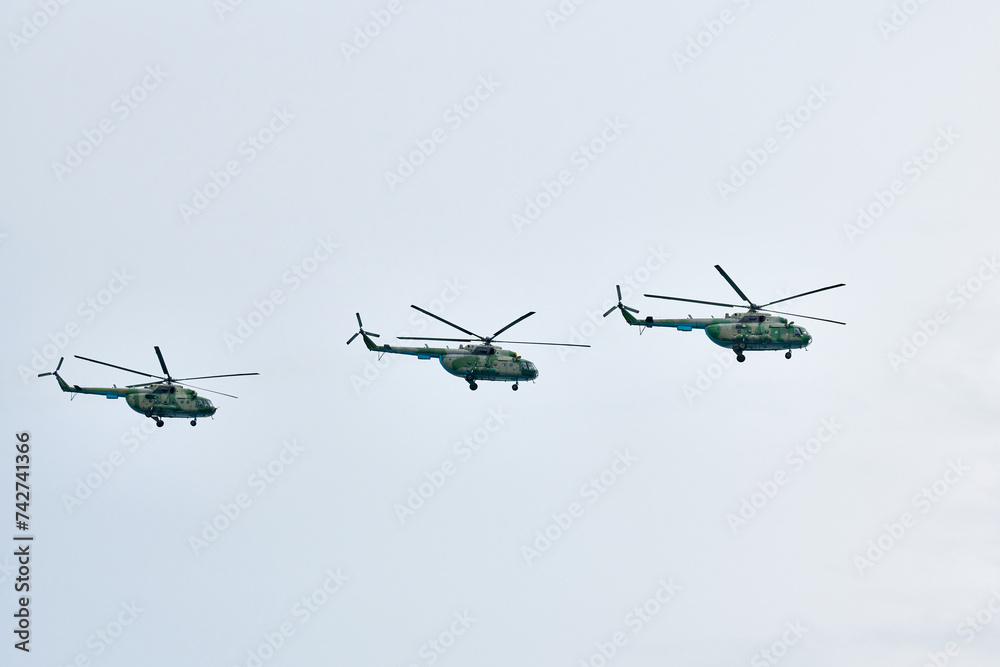 Three Russian military helicopters armed with missiles flies in blue ...
