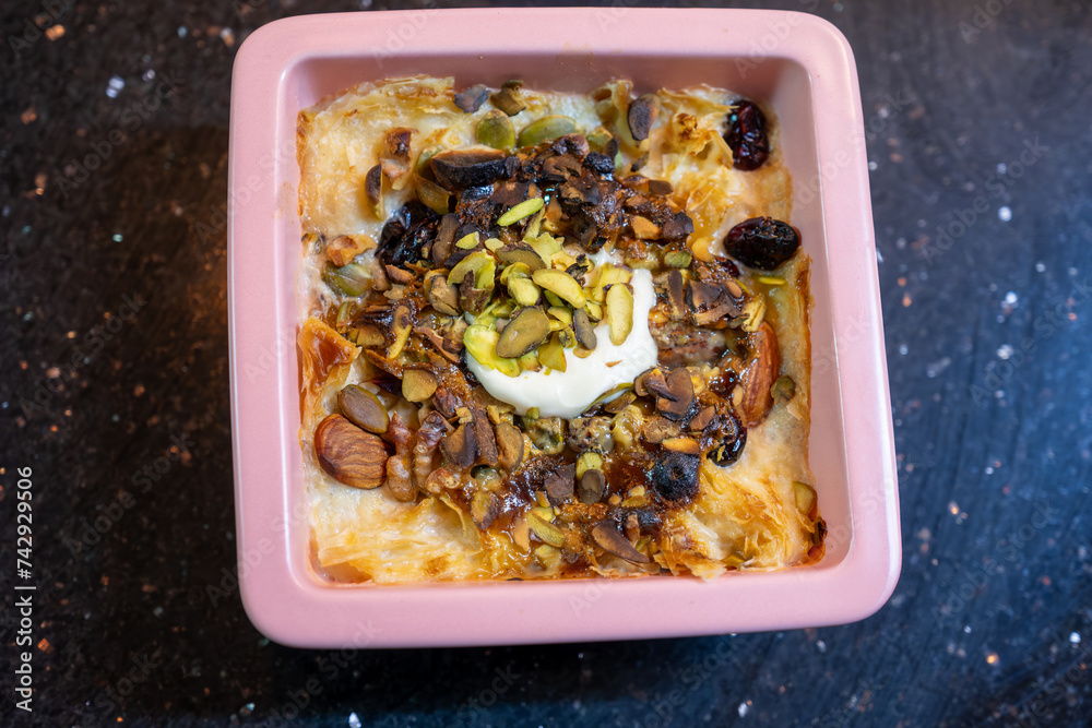 um ali is arabic sweet that made of puff pastry and nuts with milk and ...