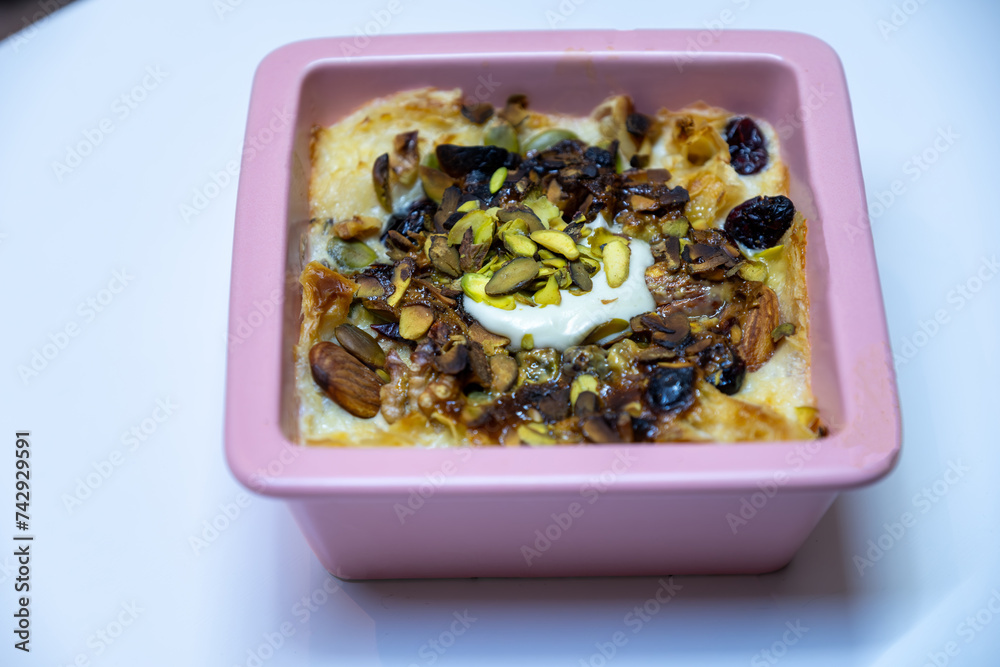 um ali is arabic sweet that made of puff pastry and nuts with milk and ...