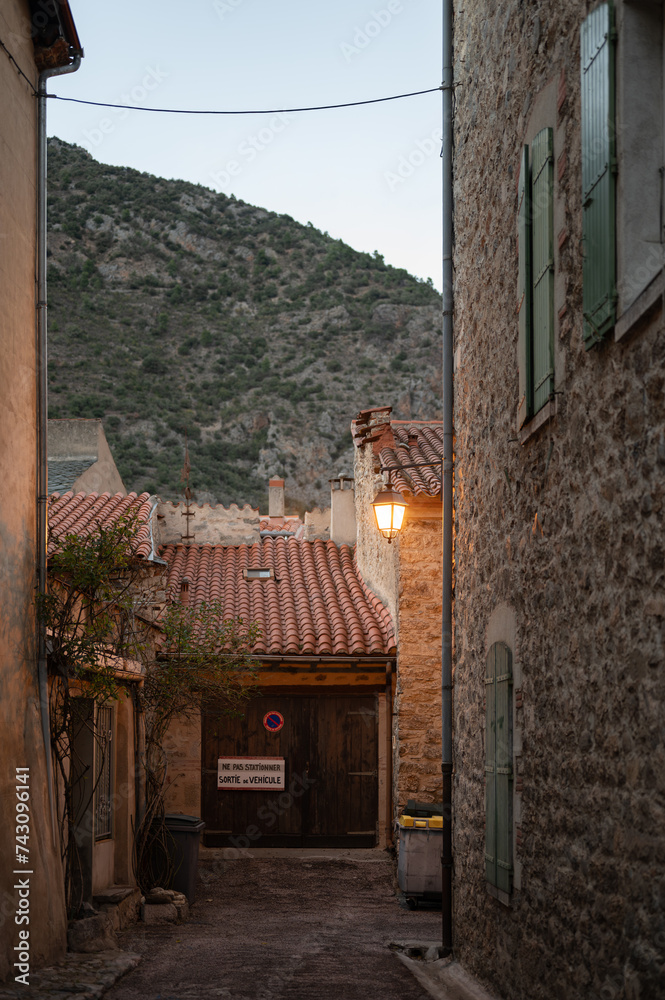 French alley of a typical village of Villefranche de Conflent at sunset ...