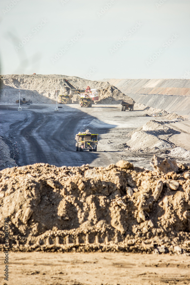 Dump trucks filling up with overburden and carting it through open cut ...
