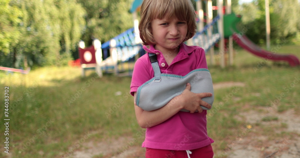 Sad child outdoors with a broken limb small, injured boy. The child has ...