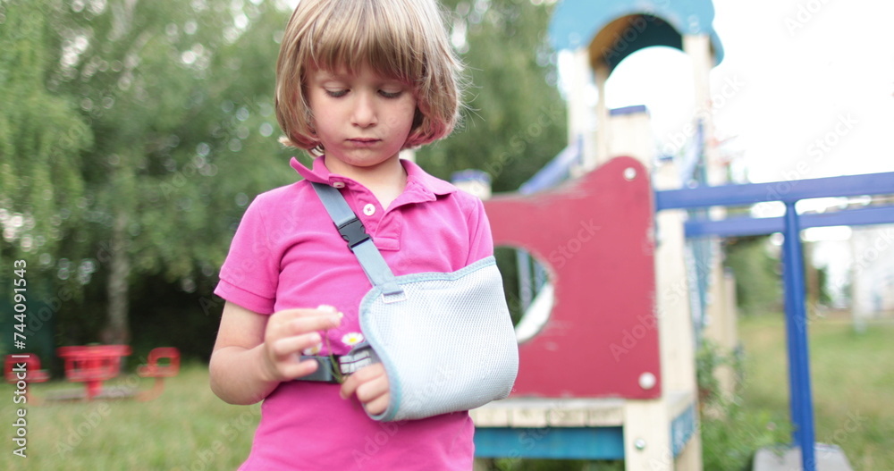 Sad child outdoors with a broken limb small, injured boy. The child has ...