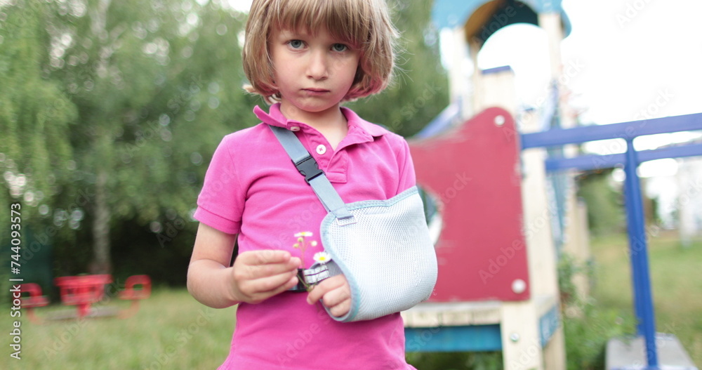 Sad child outdoors with a broken limb small, injured boy. The child has ...