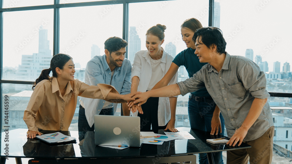 Group of multicultural businesspeople putting hands together at modern ...