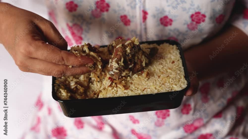 Women hand eating Mutton biryani. Packed box take away Chicken biryani ...
