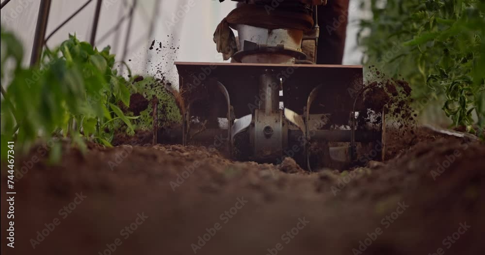 Vidéo Stock Farmer gardener with a machine cultivator digging the soil ...