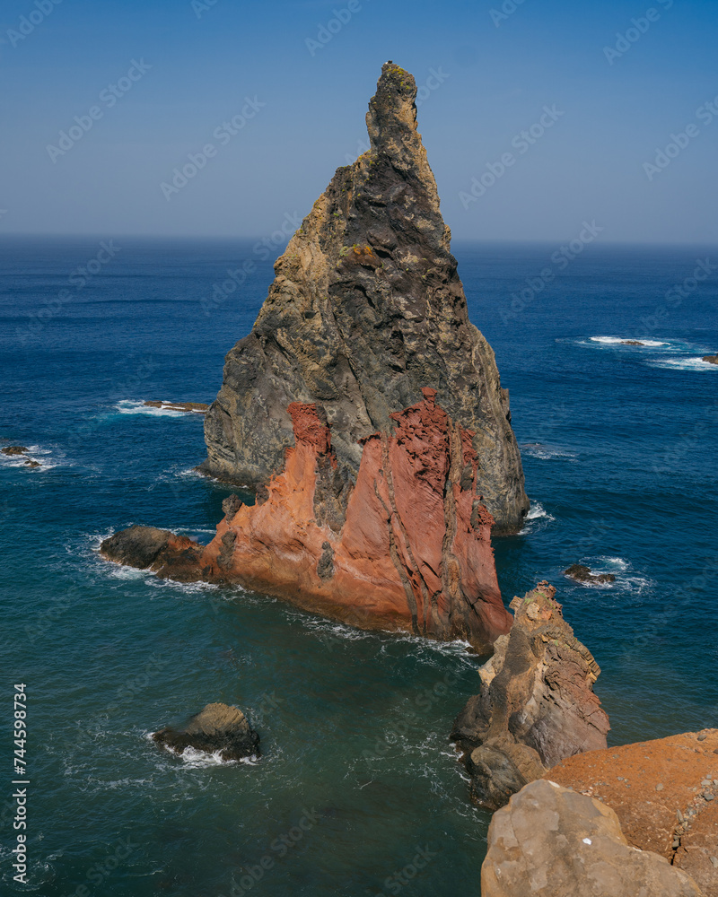 Red rock pillar protruding out of the Atlantic Ocean at the Ponta de ...