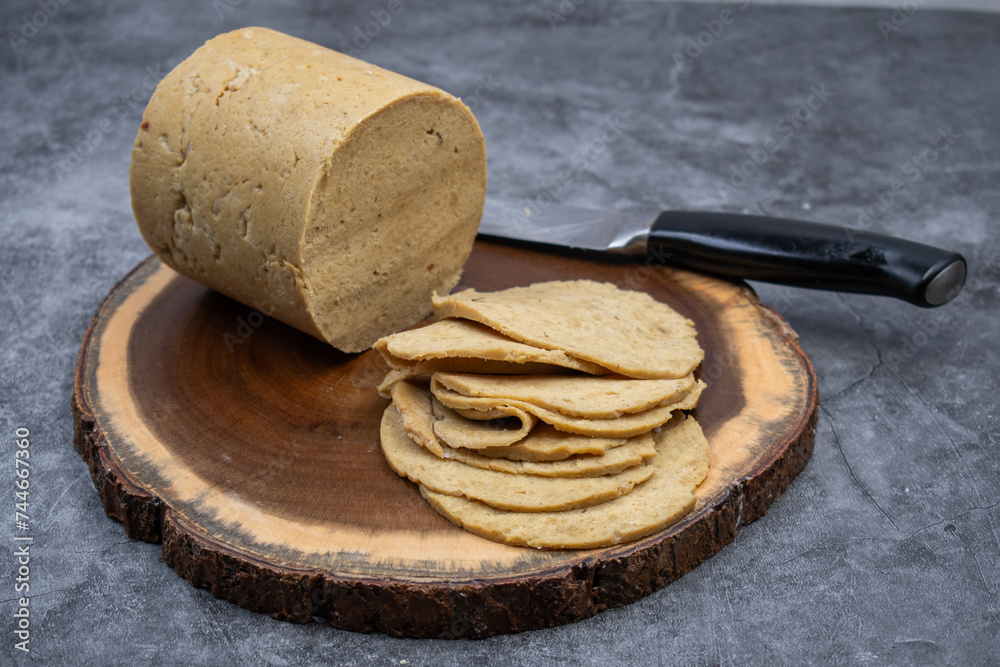 Vegan ham made in ham mold, sliced, wooden board. Mock vegan meat as ...