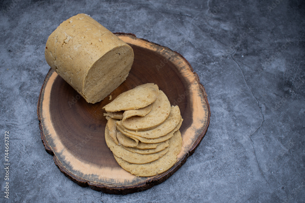 Vegan ham made in ham mold, sliced, wooden board. Mock vegan meat as ...