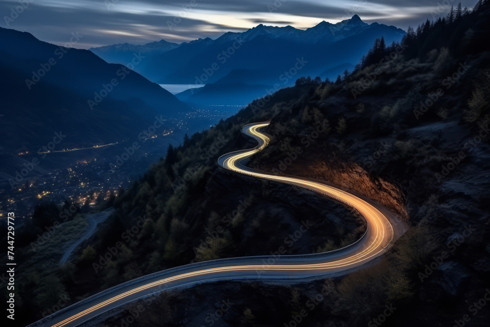 Aerial panoramic view of curvy mountain road with trailing lights at ...