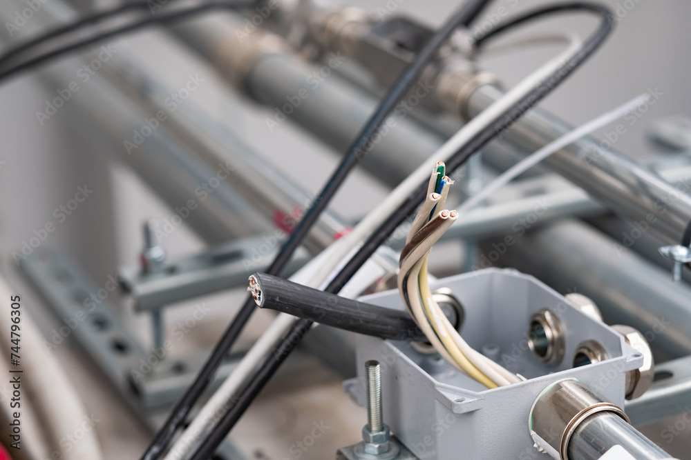 Stripped electrical wires are prepared for installation on industrial ...
