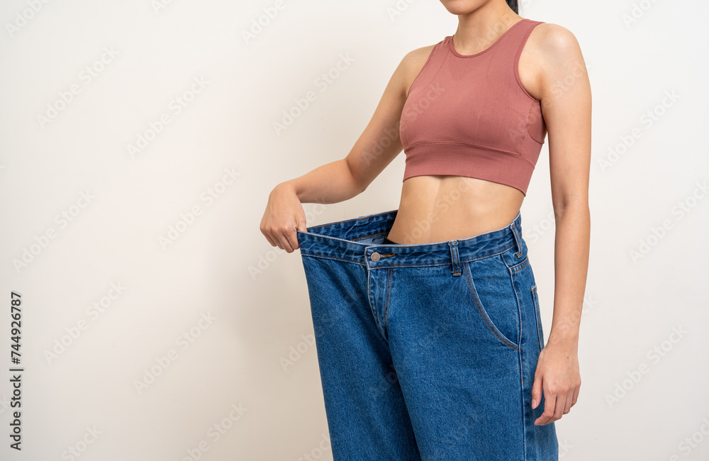 Close up thin slender abdomen waist woman wearing old big jean after ...