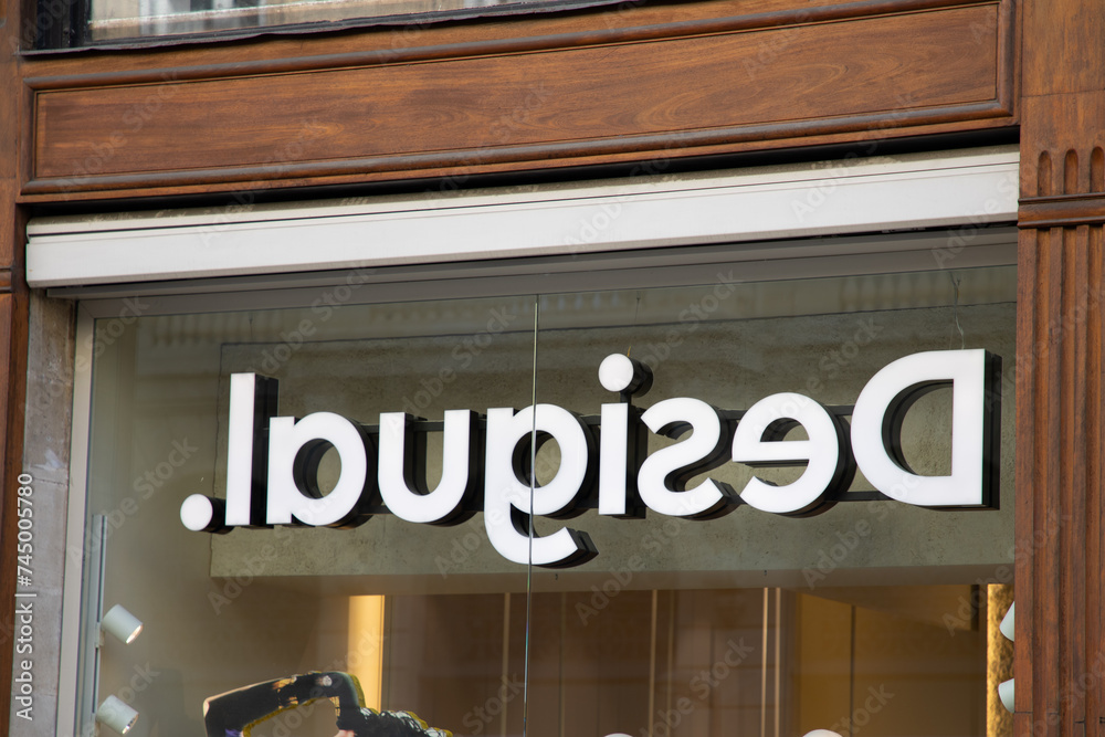 Desigual text logo inverted in mirror effect facade shop sign spanish ...