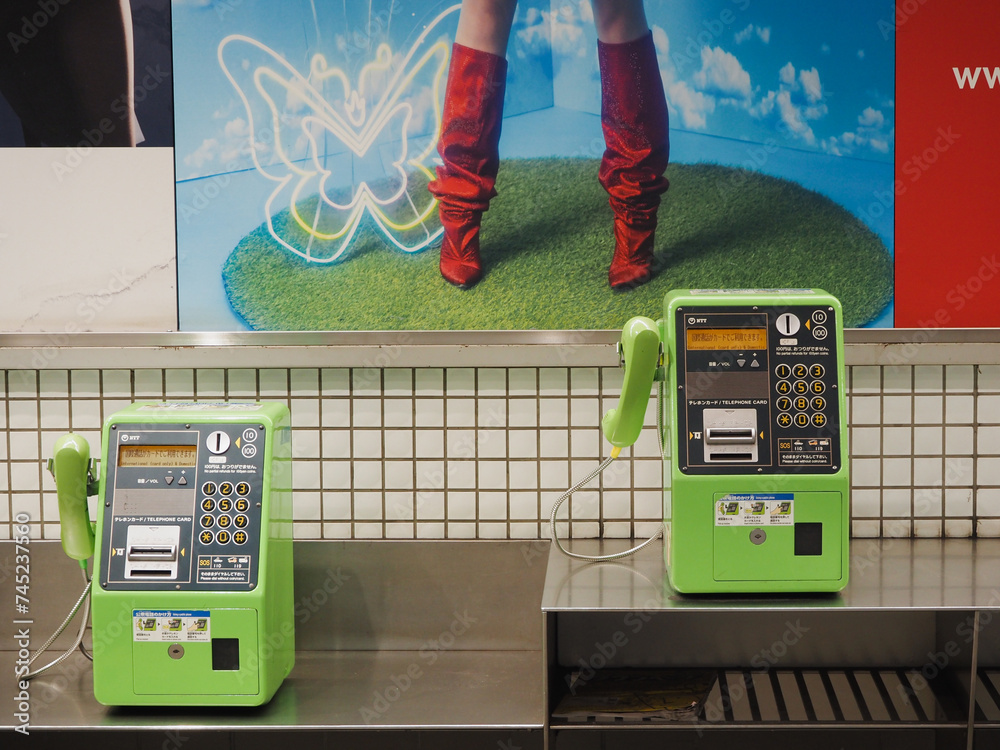 TOKYO, JAPAN - February 24, 2024: A pair of payphones inside a subway ...
