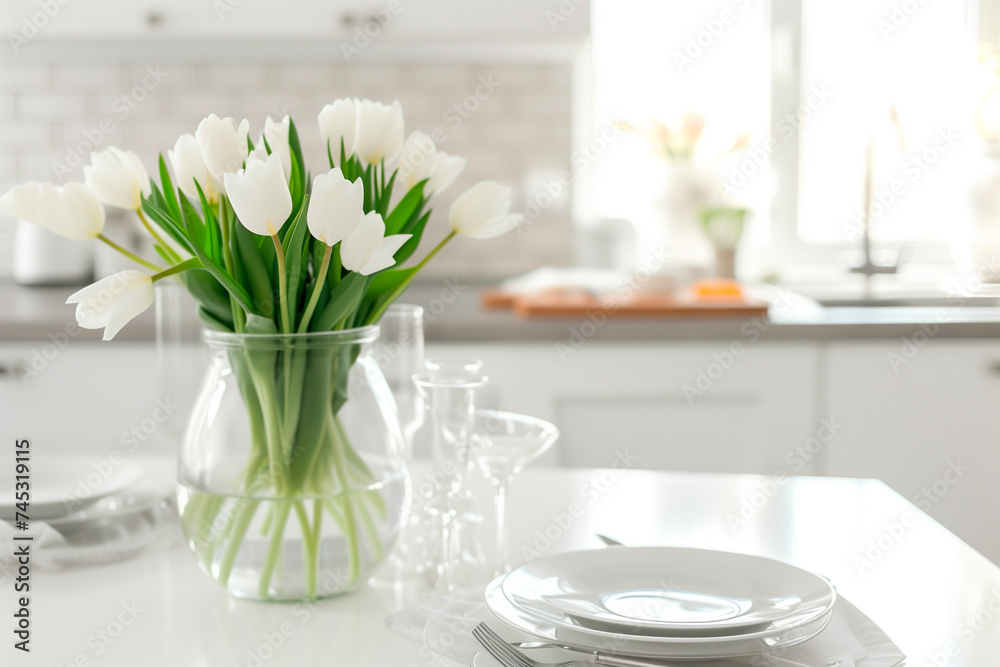 Spring-themed dinner table in white kitchen with fresh white flowers as ...