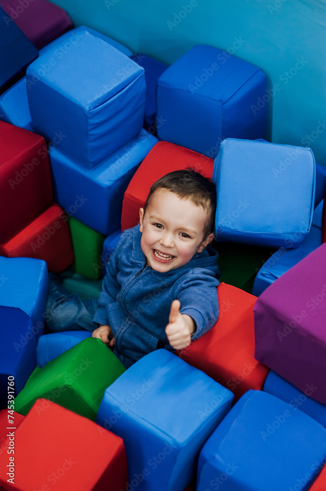 Little boy preschooler, happy laughing child lies playing with soft ...