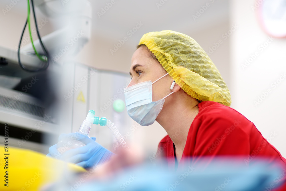 Female anesthesiologist injects anesthesia into patient face mask ...