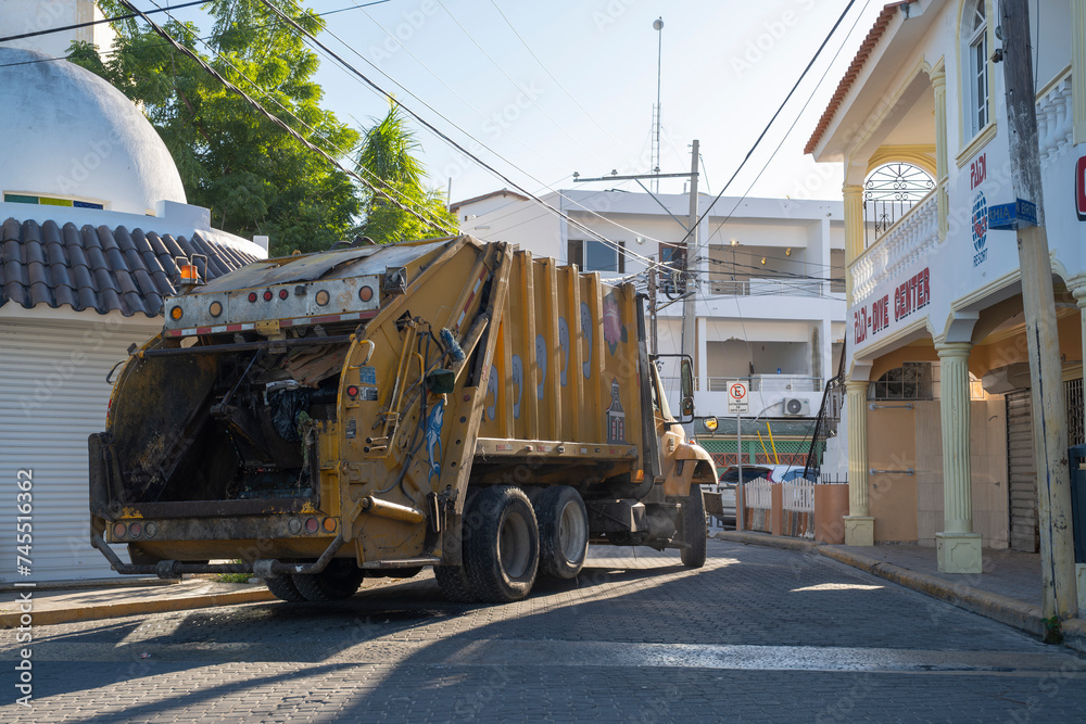 Garbage truck drives through a small Tourist town Bayahibe in the ...