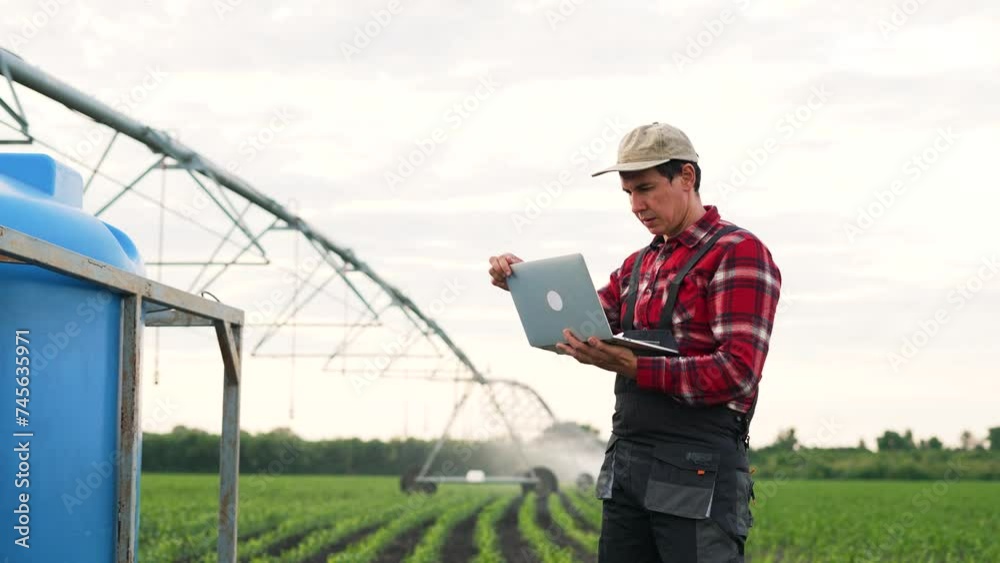 Agriculture.Farmer engineer is work with laptop in field.Automatic ...