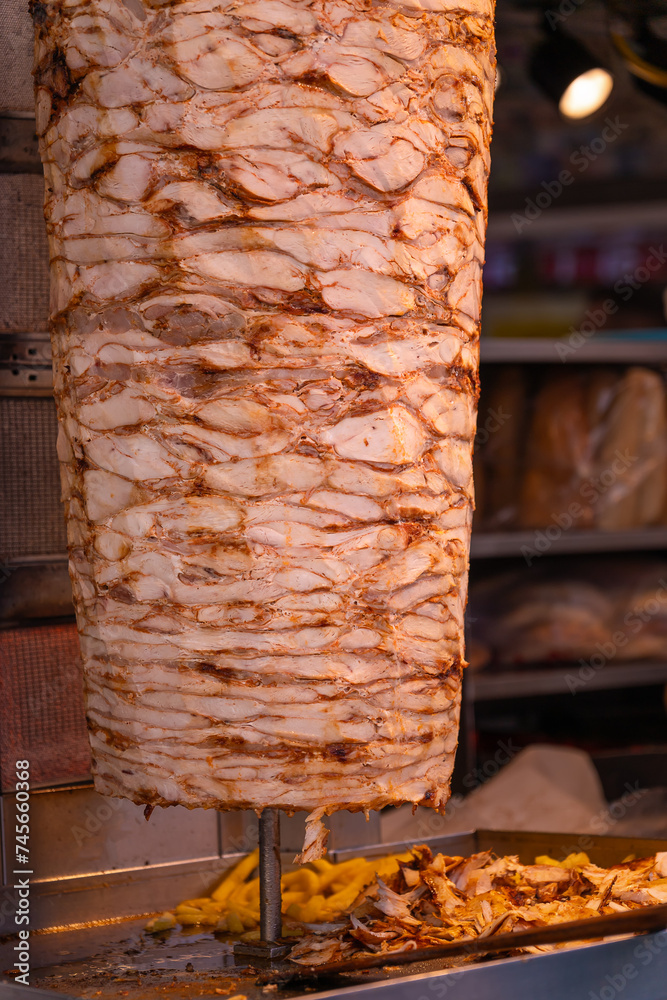 Close-up of grilled meat on a vertical grill is used in traditional ...