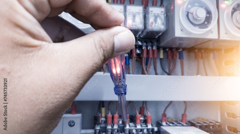 Checking the electrical power on the control panel using a test pen, a ...