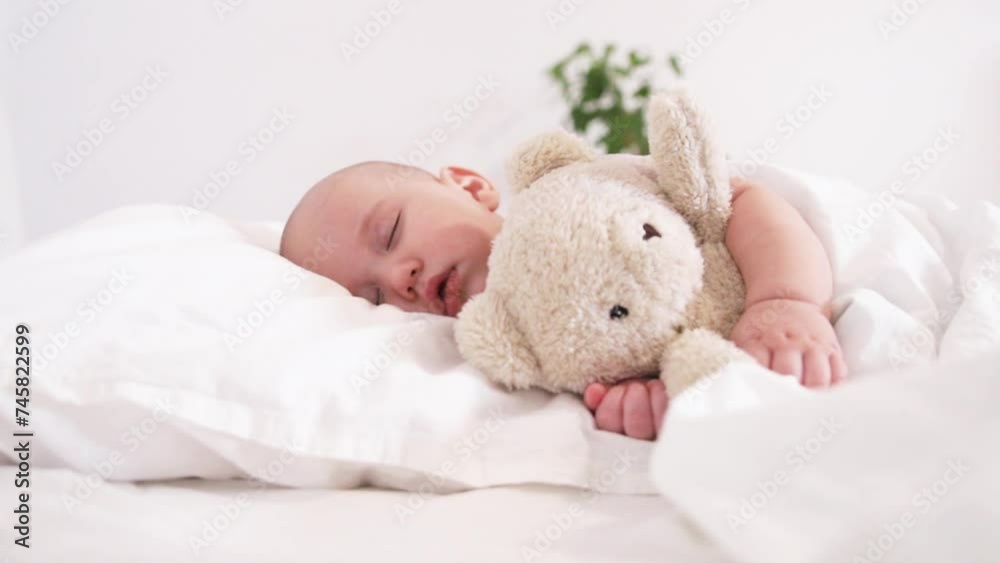Adorable child holding teddy bear sleeping sweetly on white bed on ...
