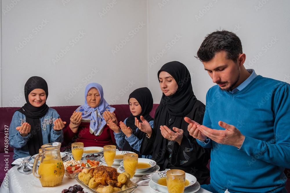 Muslim family making iftar dua to break fasting during Ramadan happy ...