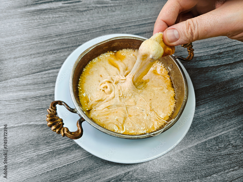 Male hand dipping bread to traditional Turkish meal called Mihlama ...