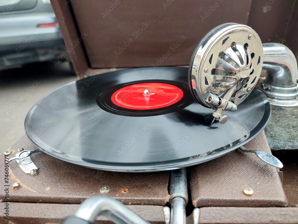 An old retro record playing on old vintage gramophone at flea market ...