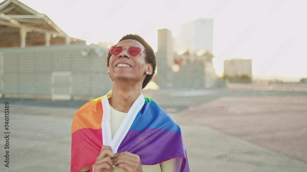 African American gay man with rainbow LGBT flag at Pride parade ...