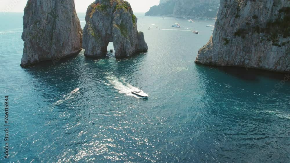 Capri Island with Faraglioni cliffs against a backdrop of a bustling ...