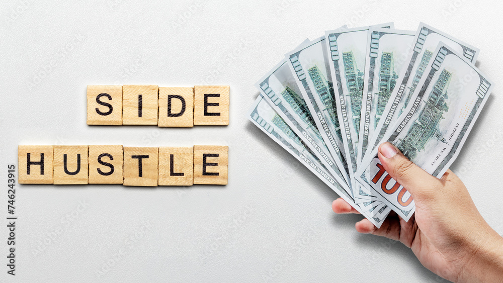 Man's hand holding dollars in his hands with text from wooden cubes ...