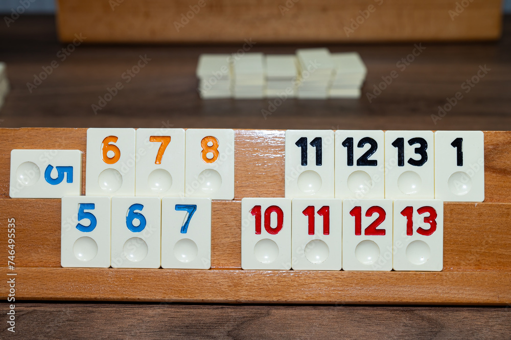 Board game, numbers and colours on a wooden floor. Rummikub, a board ...