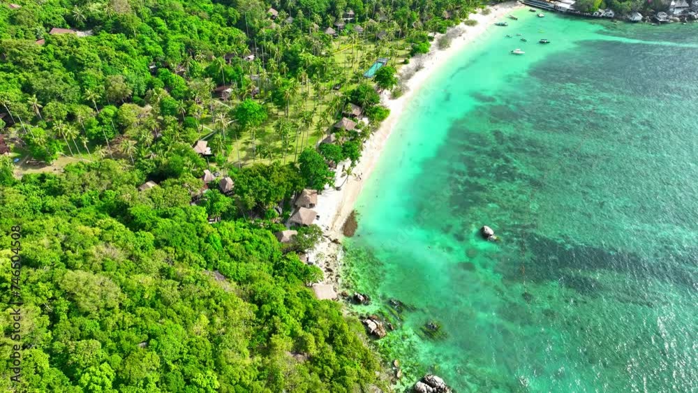 Lush trees frame a pristine sandy shore, where azure waters embrace a ...