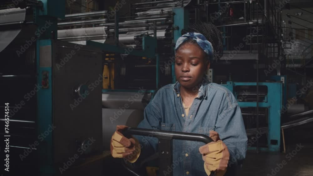 Waist up lowkey shot of tired Black female factory worker pulling hand ...