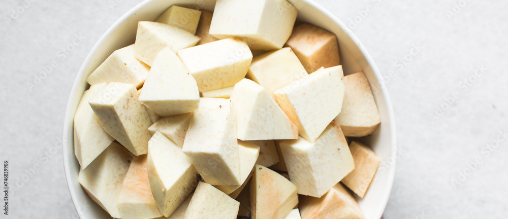 Overhead view of Nigerian white yam cubes in a white ceramic bowl ...