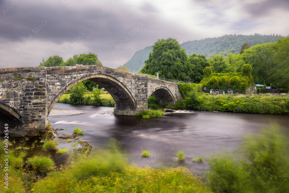 Historic steep stone arch bridge crossing a river - Pont Fawr (Inigo ...
