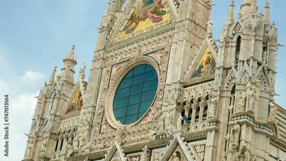 Slow tilt up of the façade of the Siena Cathedral, a medieval church in ...