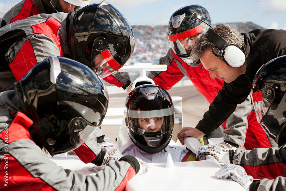 Race car driver gearing up for the big race with the pit crew team ...